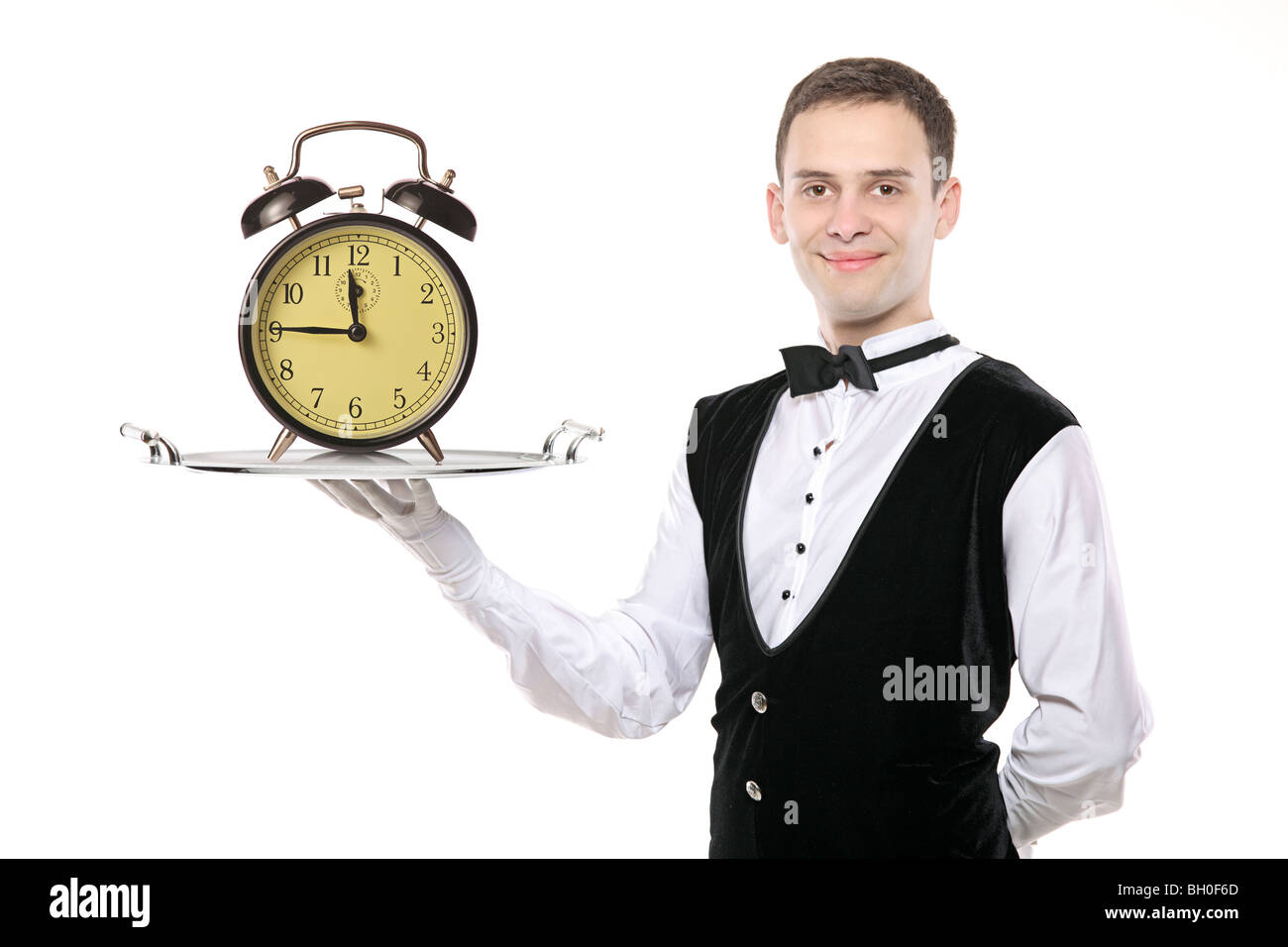 Butler holding a tray with a clock isolated on white Stock Photo - Alamy