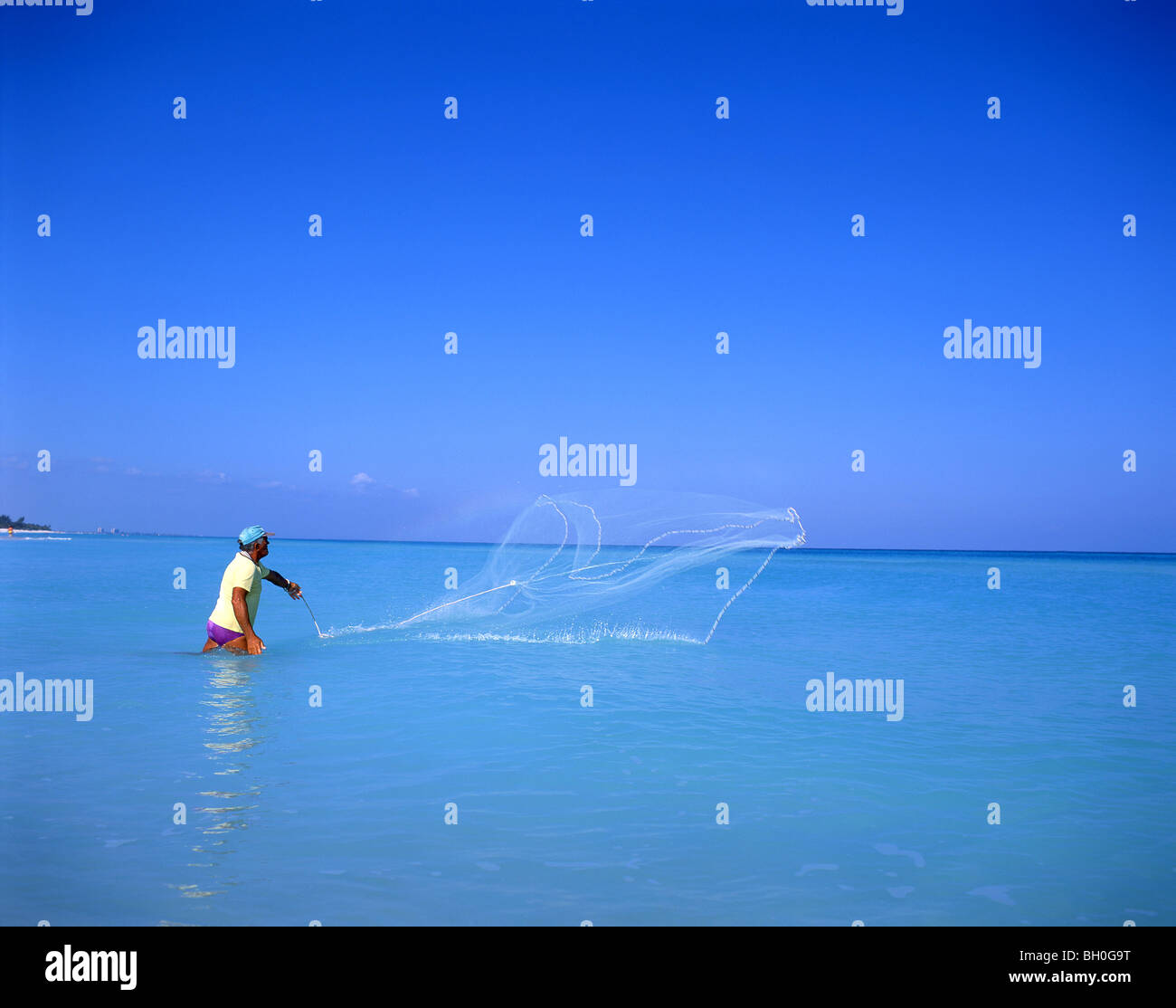 Local man with fishing net on tropical beach, Varadero, Matanzas ...