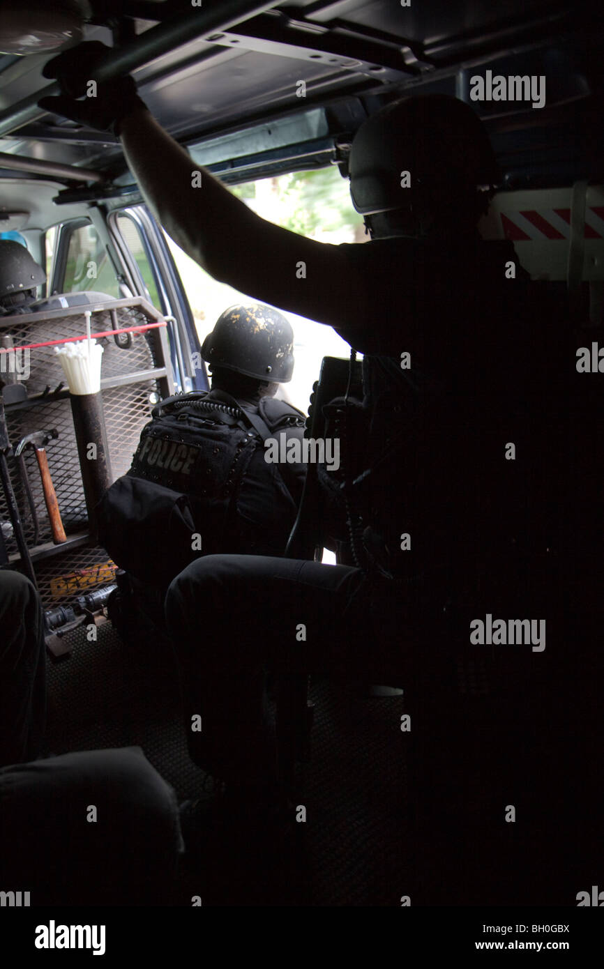 Tactical police officers exiting van ready to serve high-risk drug ...
