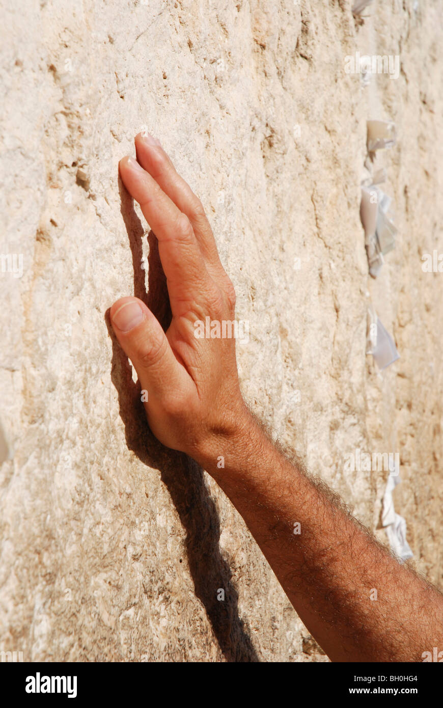 Israel, Jerusalem Old City, close up of a male hand touches the Wailing ...