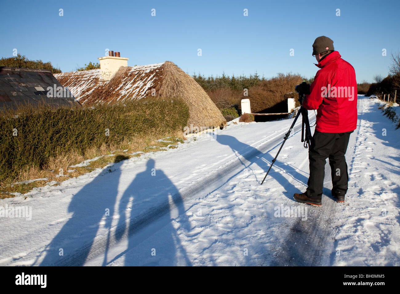 Photographer photographing snow scene, Ireland Stock Photo - Alamy