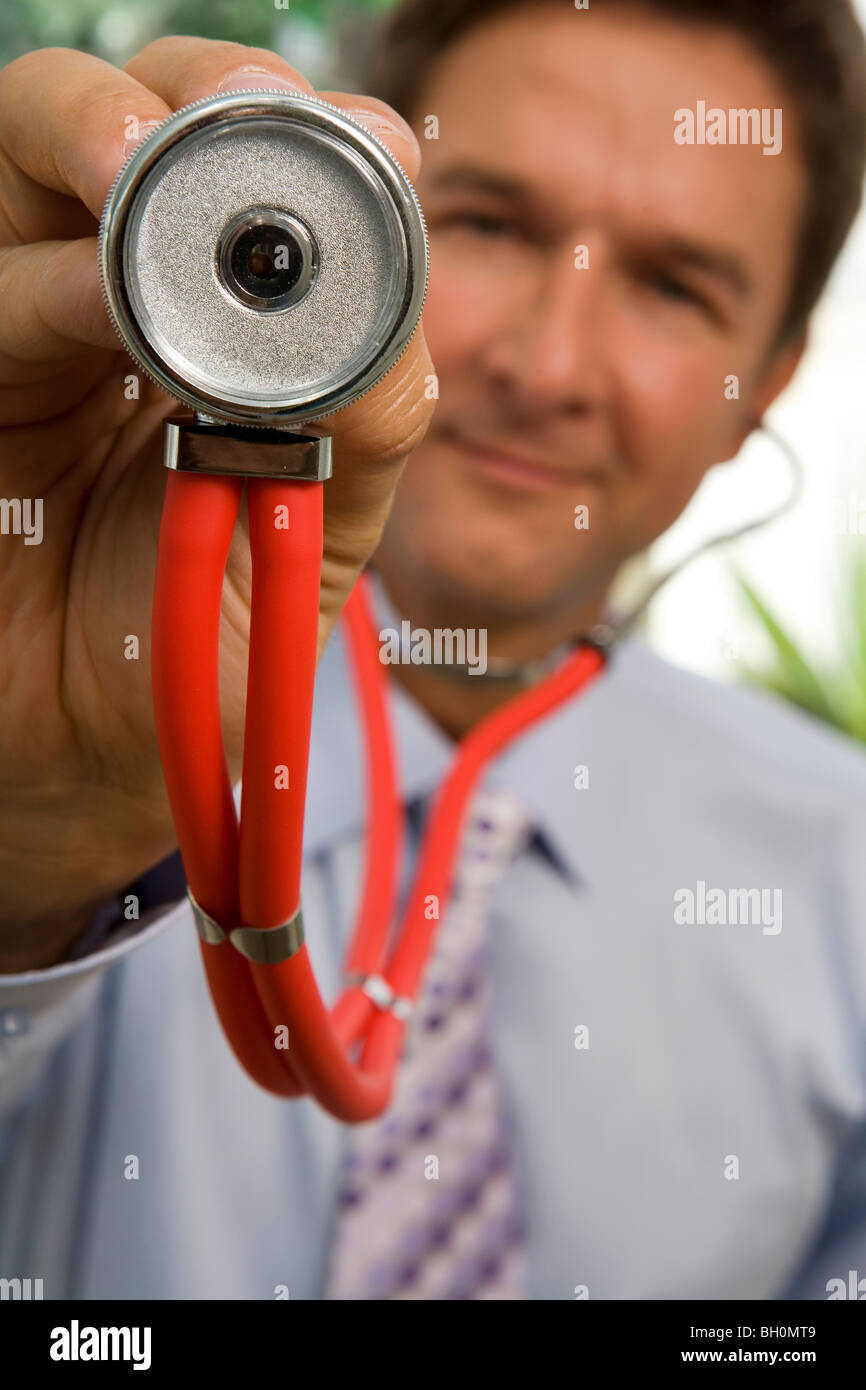 A white doctor with a red tube stethoscope prepares to check a patient ...