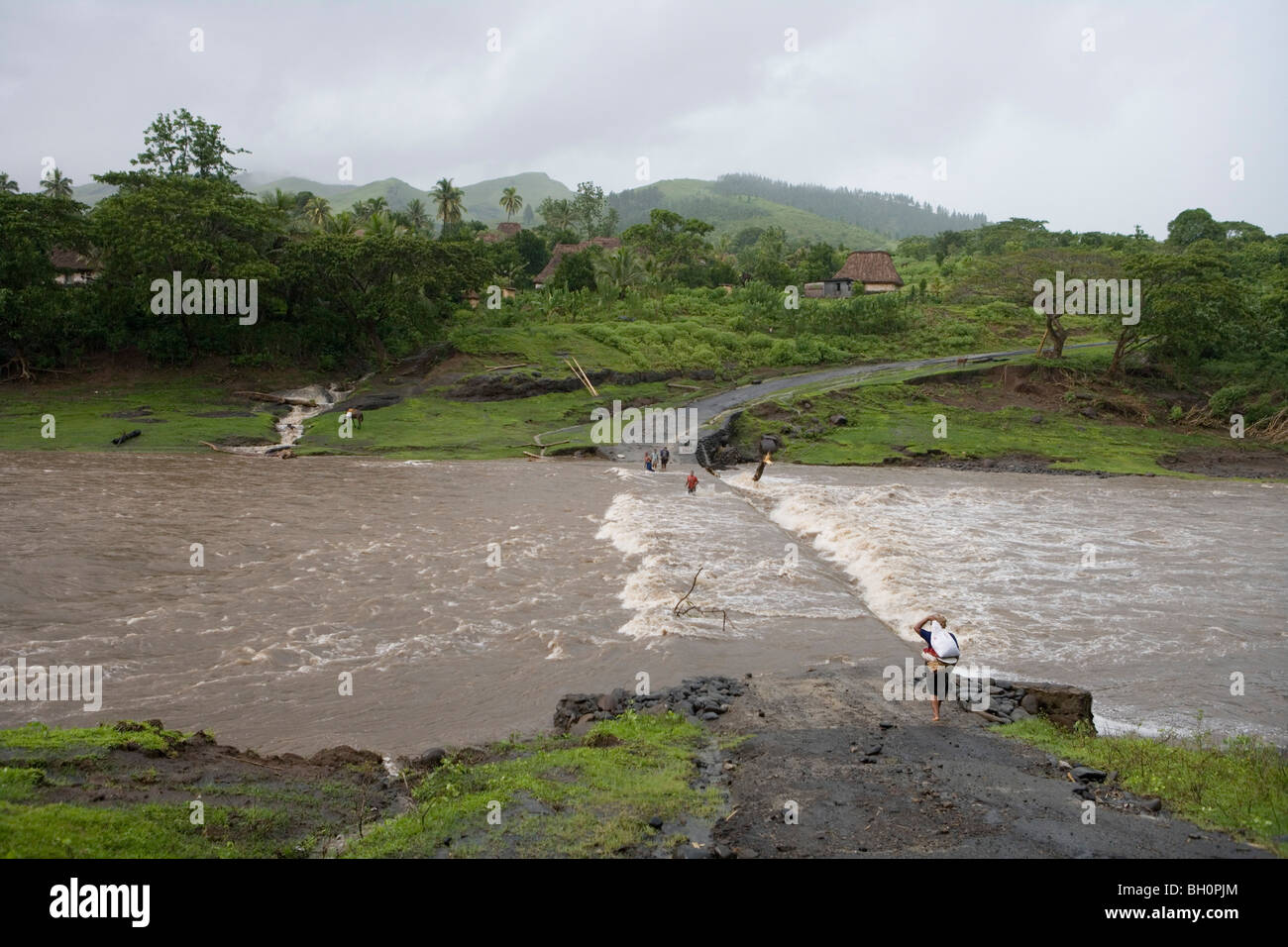 Floodwater river flooding a road at Nausori Highland, Navala, Viti Levu ...