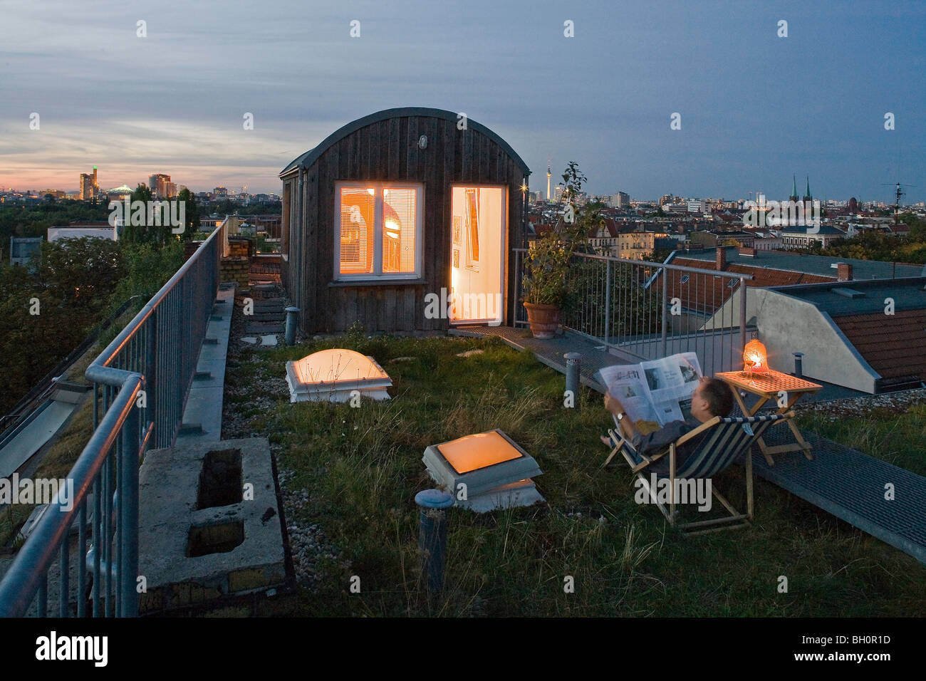 man reading newspaper on a roof-deck, Berlin, Germany Stock Photo - Alamy