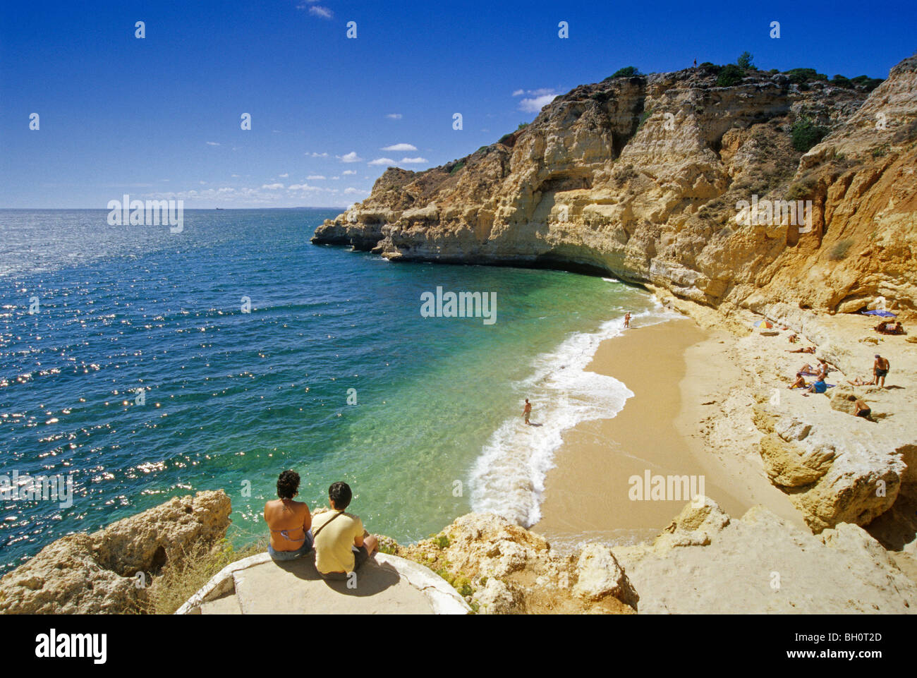 People on the beach in a bay under blue sky, Praia do Paraiso, Algarve ...