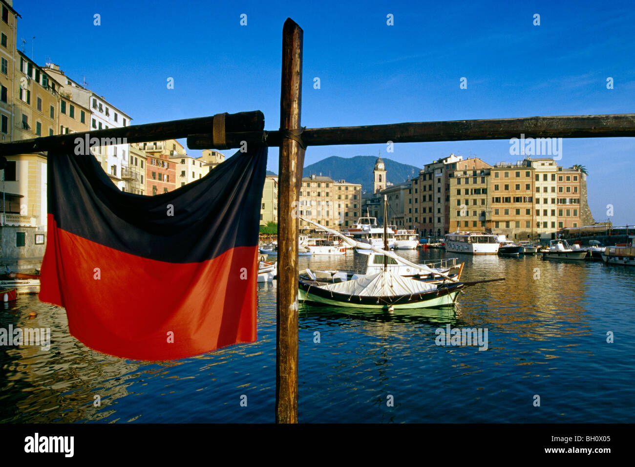 Black and red flag at the harbour under blue sky, Camogli, Liguria ...