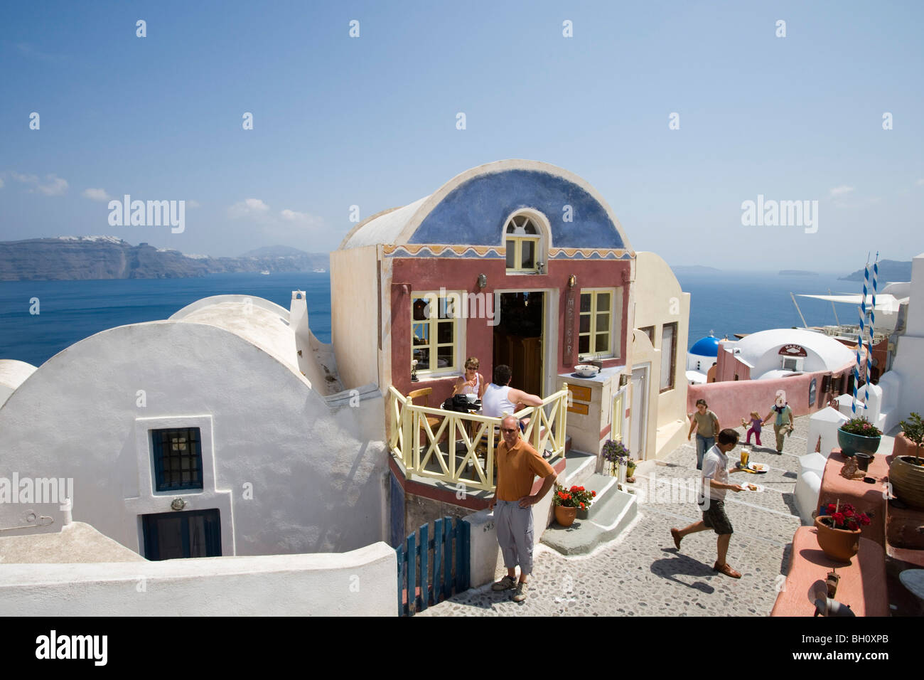 People at the Meteor Bar and Restaurant in the sunlight, Oia, Santorini ...