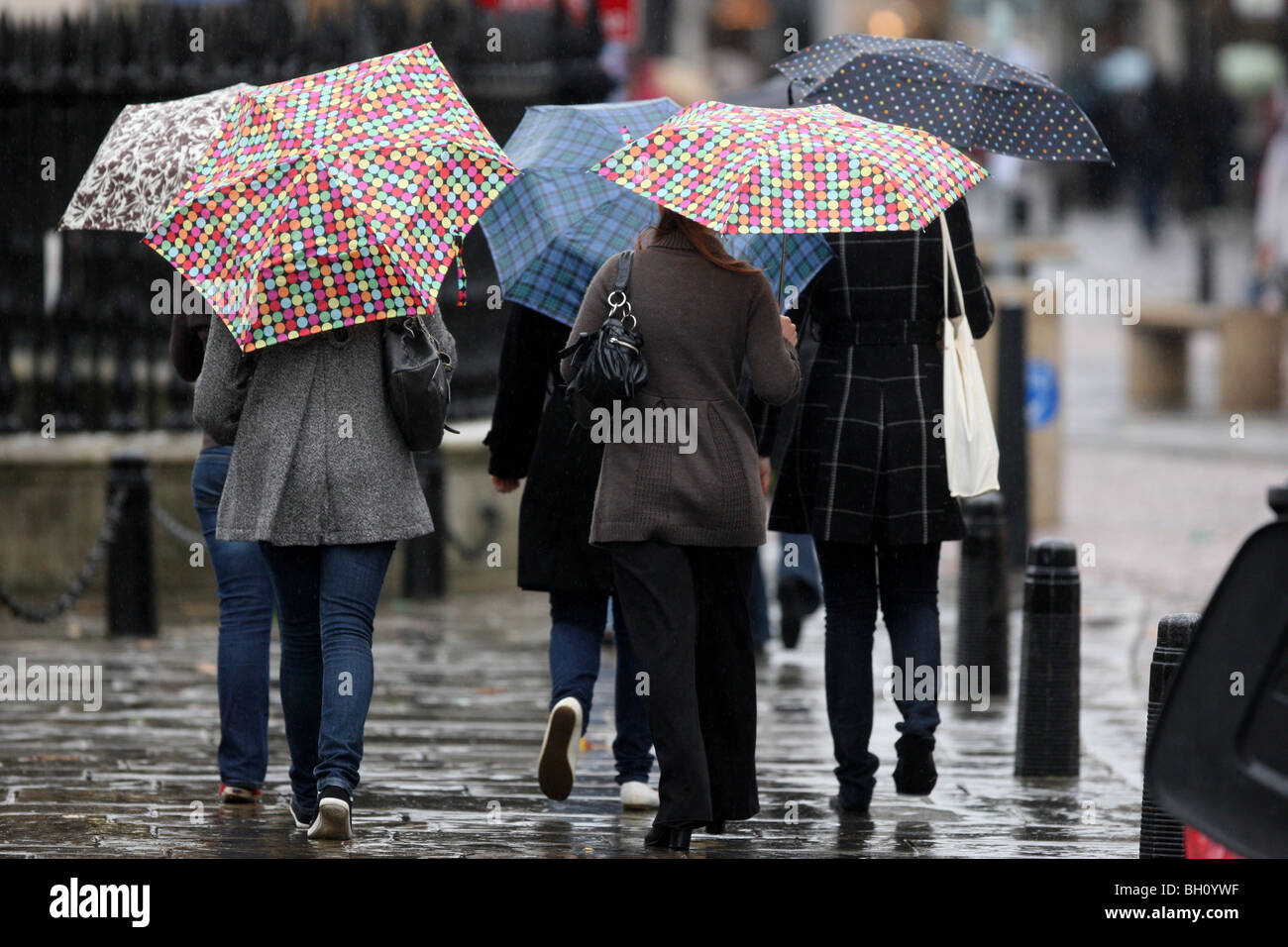 PEOPLE SHELTERING FROM THE RAIN WITH UMBRELLAS Stock Photo - Alamy