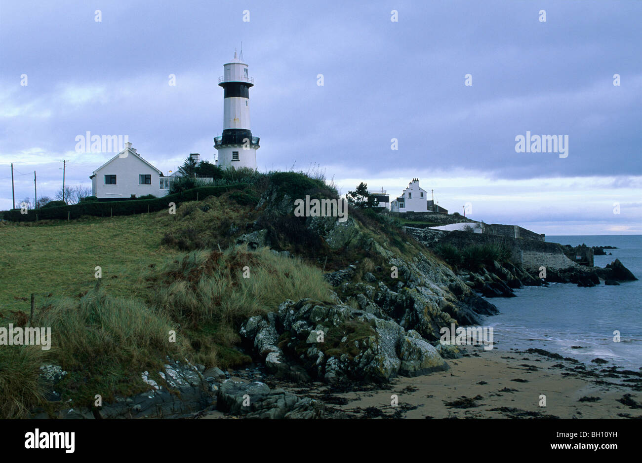 Lighthouse and houses at Dunagree Point under clouded sky, Peninsula ...