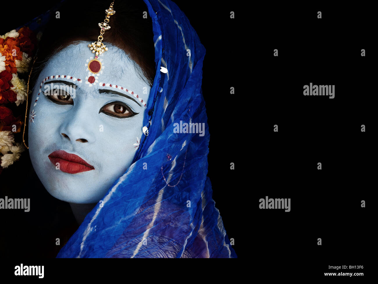 Indian girl face painted as the Hindu goddess Sita against a black ...