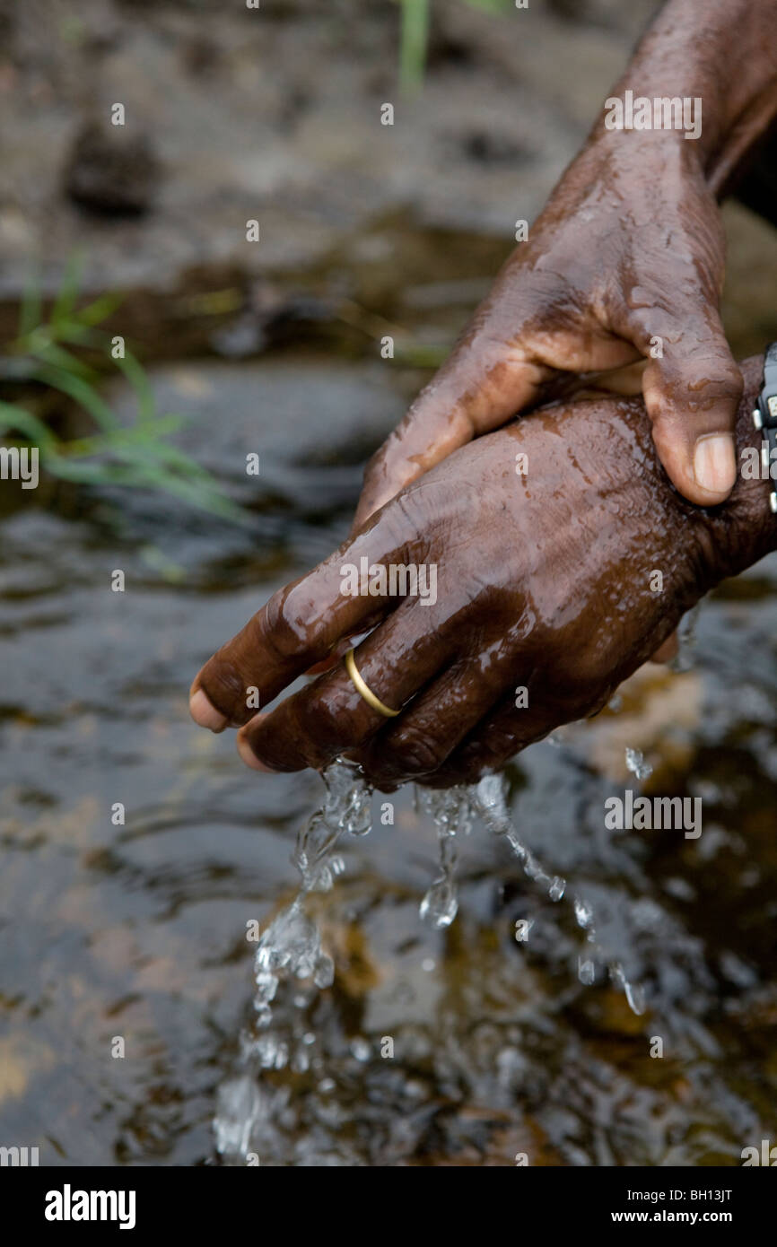 African man washing hands in stream Stock Photo - Alamy