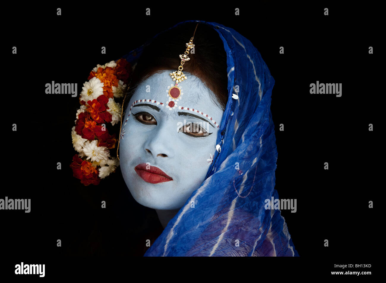 Indian girl face painted as the Hindu goddess Sita against a black ...