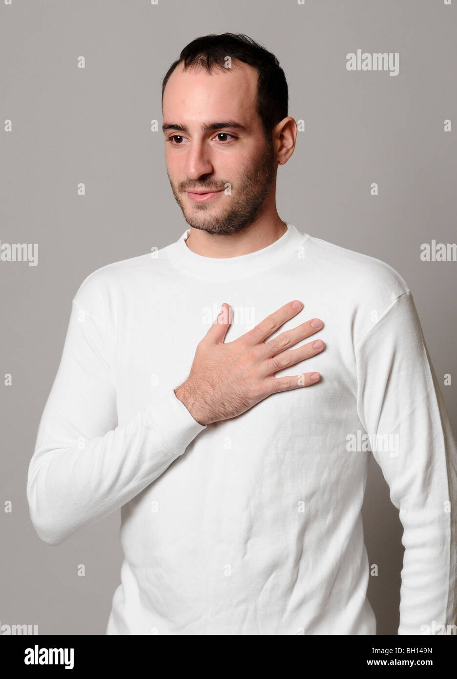 Young male model in his 20s puts his hand on his heart Model Release ...
