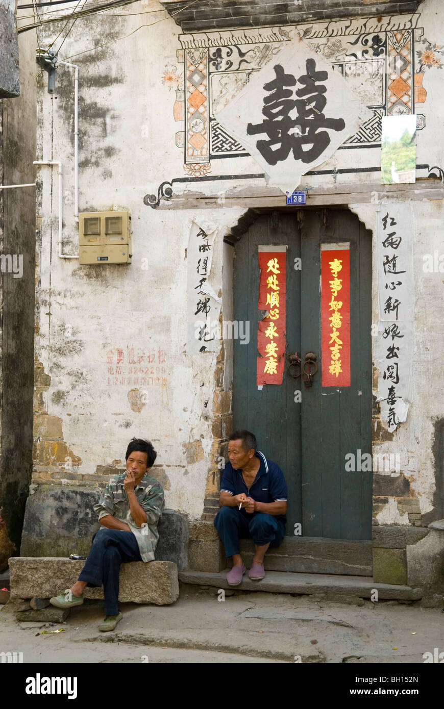 Two men sitting in front of an old Huizhou style house in Big Likeng ...