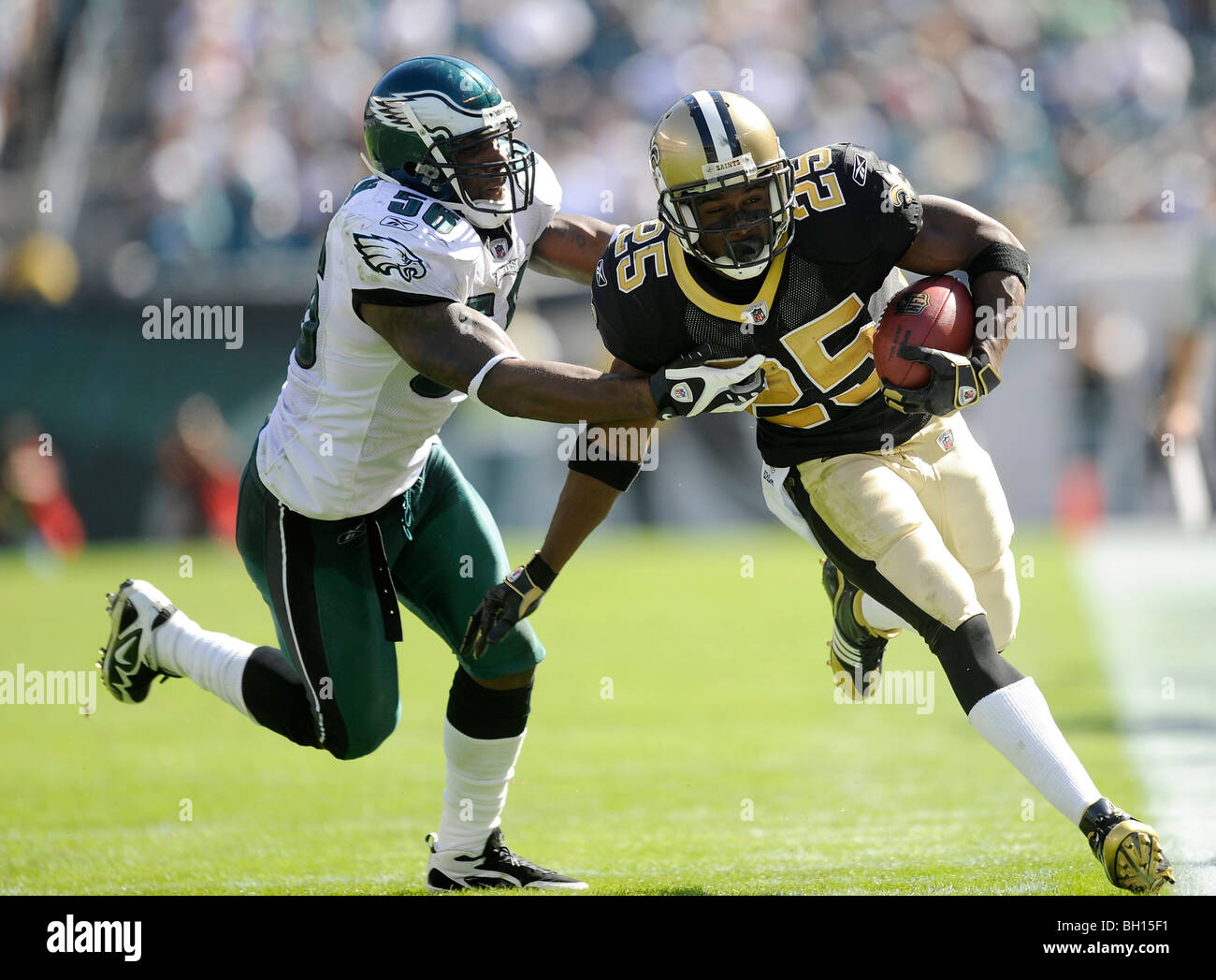 Reggie Bush #25 of the New Orleans Saints runs with the ball as Akeem ...
