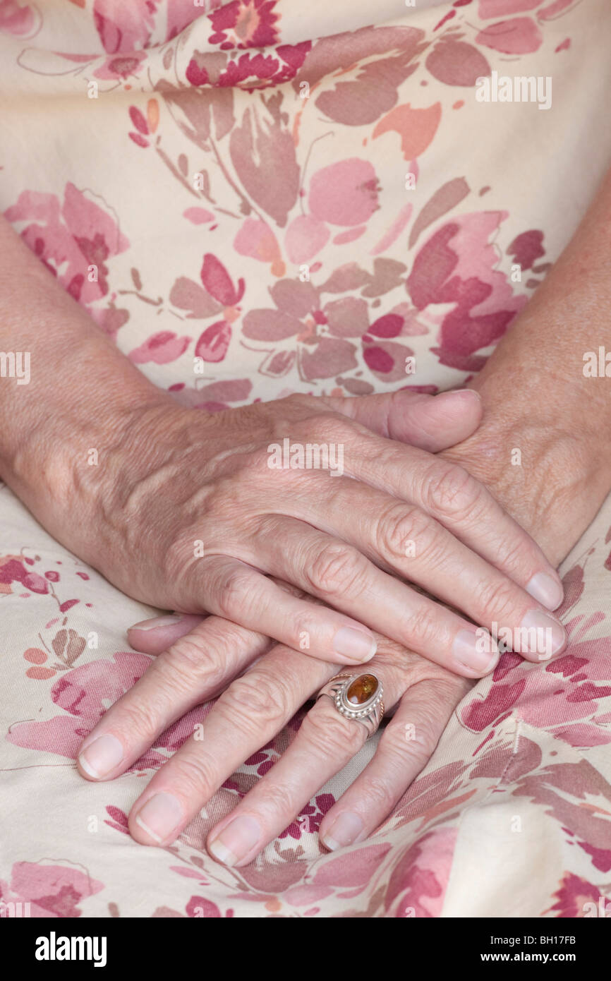 Senior woman seated with hands at rest on lap Stock Photo - Alamy