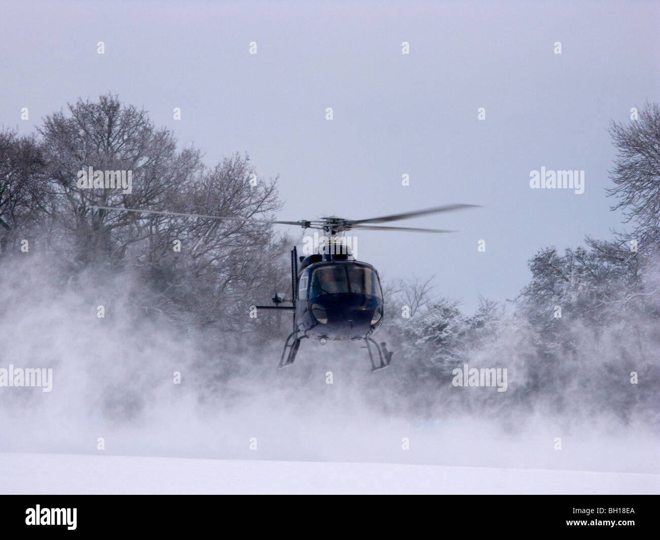 helicopter in the snow kicking up lots of snow as it lands Stock Photo ...