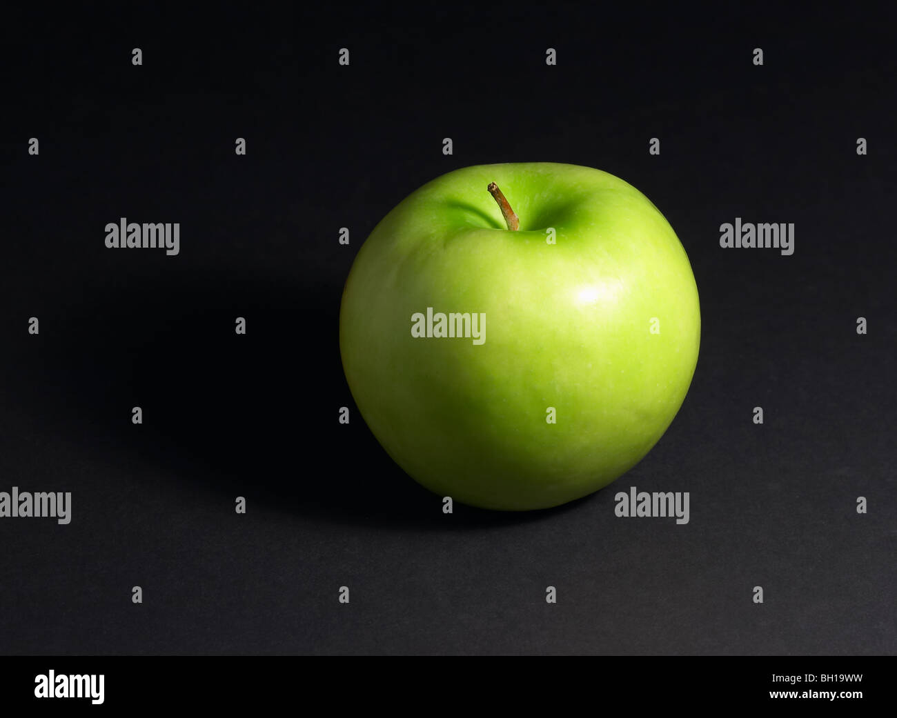 Green apple on black background with small shadow Stock Photo - Alamy