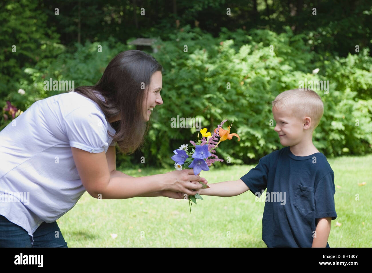 A little boy giving his mother flowers Stock Photo - Alamy