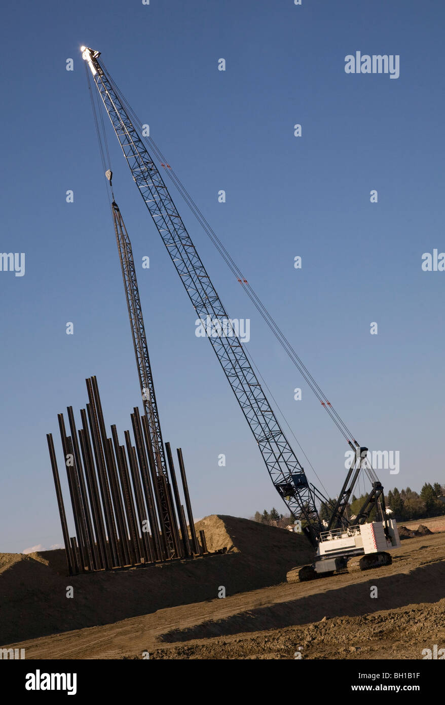 Crane lowering pilings for bridge construction Stock Photo - Alamy