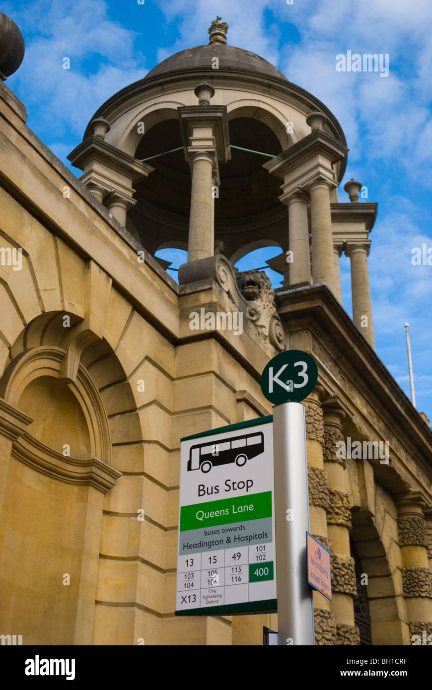Bus stop sign in front of Queens College High street central Oxford ...