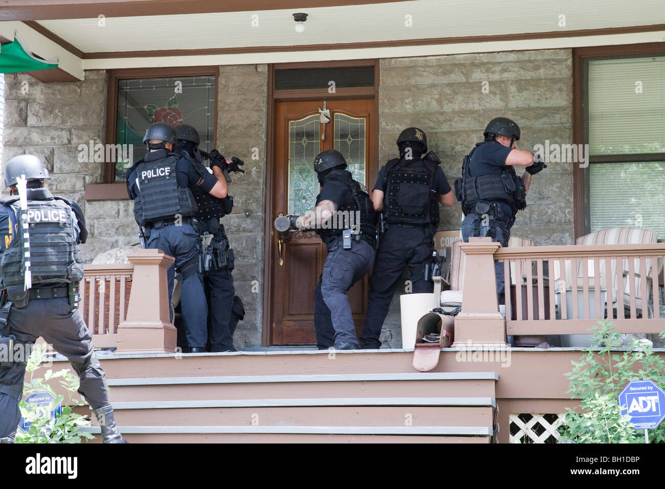 Police tactical team making entry serving a high risk drug related ...