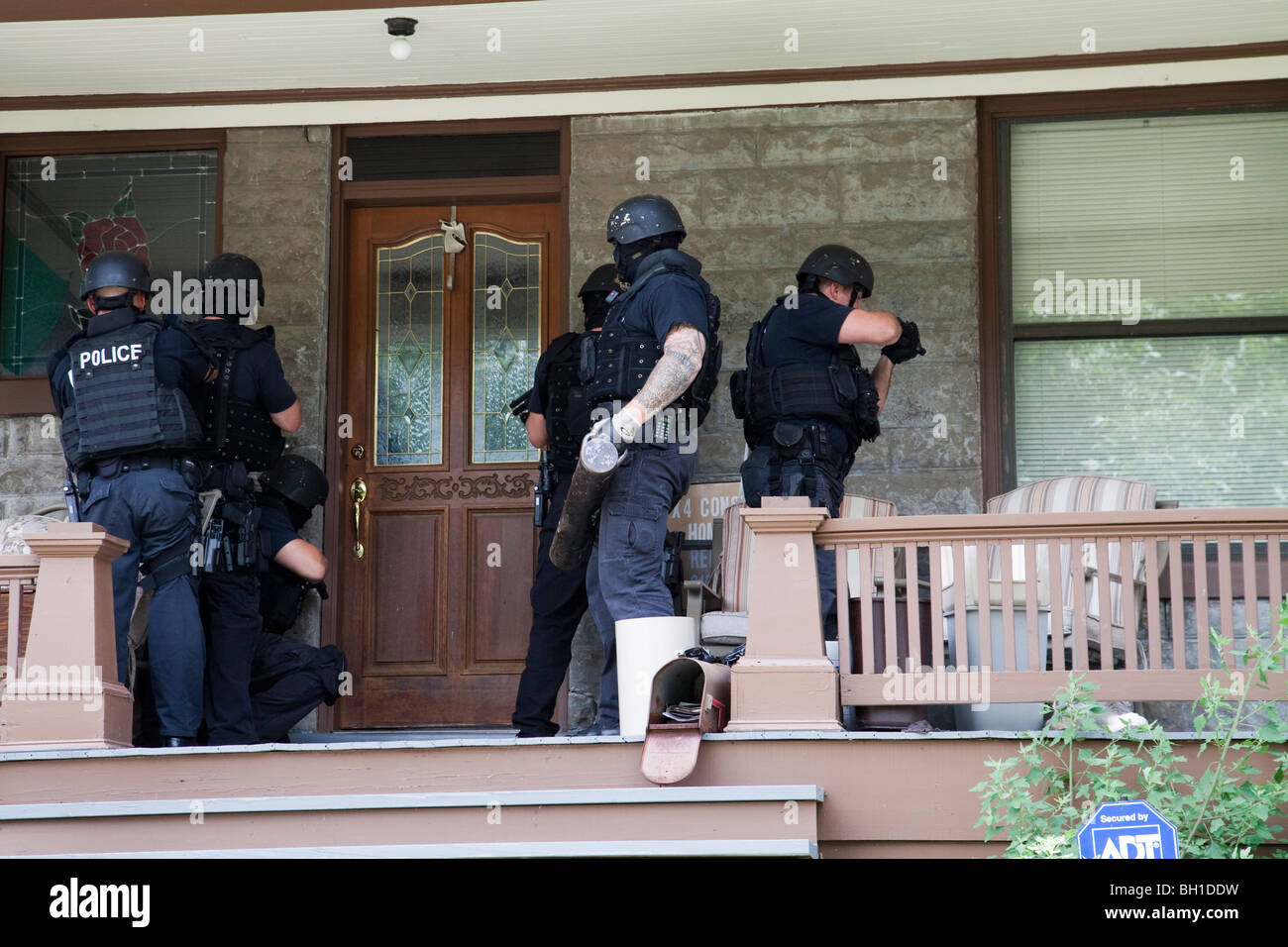 Police tactical team making entry serving a high risk drug related ...