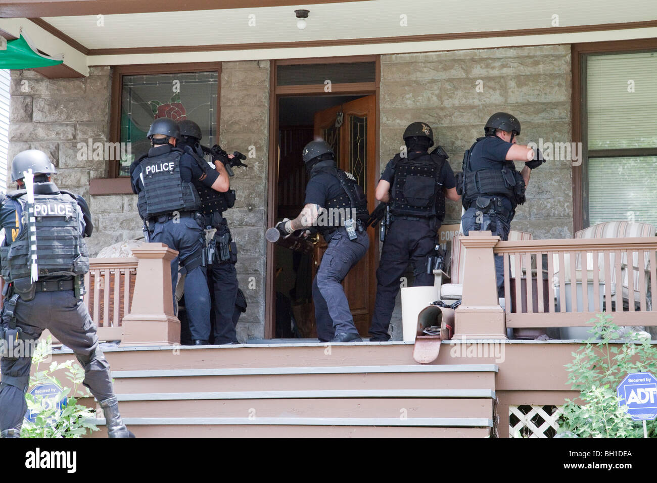 Police tactical team making entry serving a high risk drug related ...