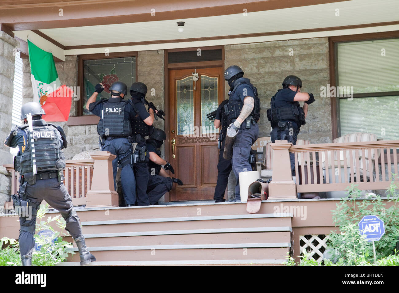 Police tactical team making entry serving a high risk drug related ...