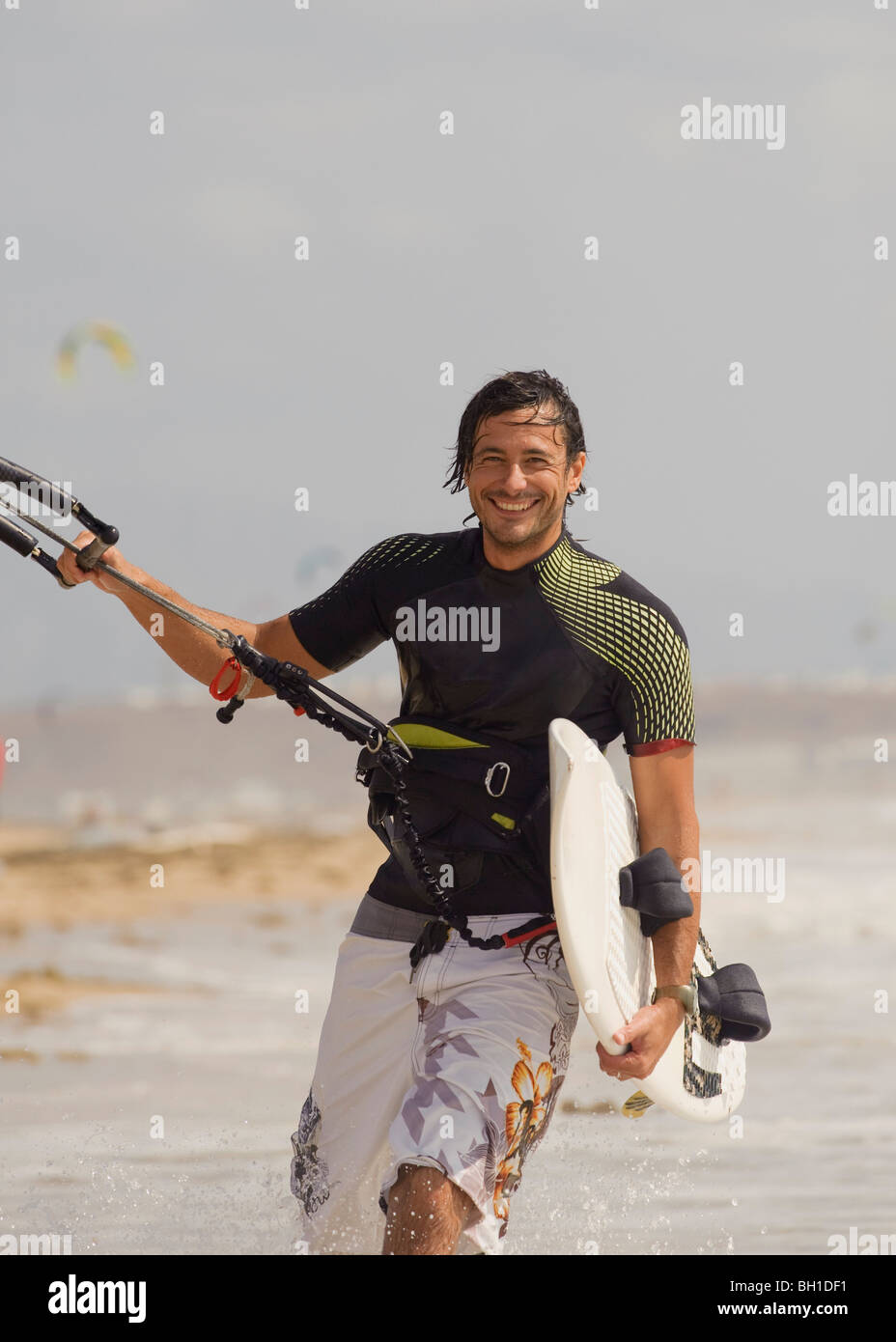 Man carrying kitesurfing board Stock Photo - Alamy