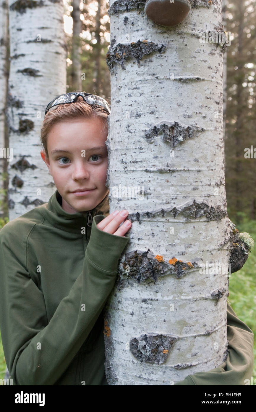 Young girl with arm around tree, Manitoba, Canada Stock Photo - Alamy