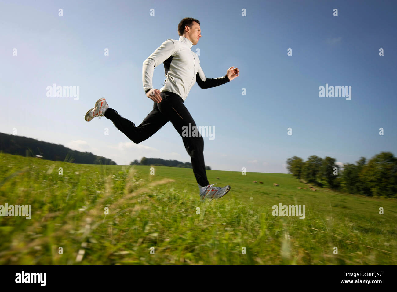 Man running over meadow Stock Photo - Alamy