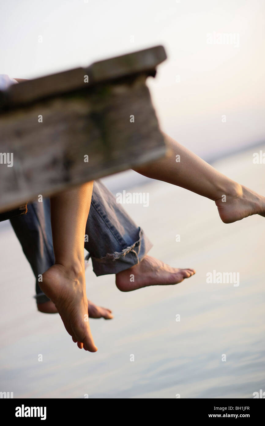 Couple sitting on a jetty, Ambach, Lake Starnberg, Bavaria, Germany ...