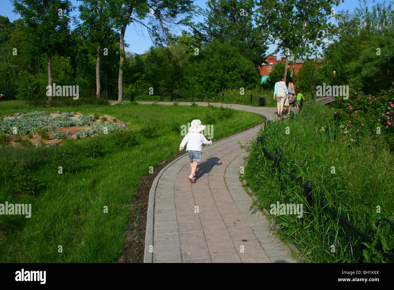 Small child girl walking in urban park Stock Photo - Alamy