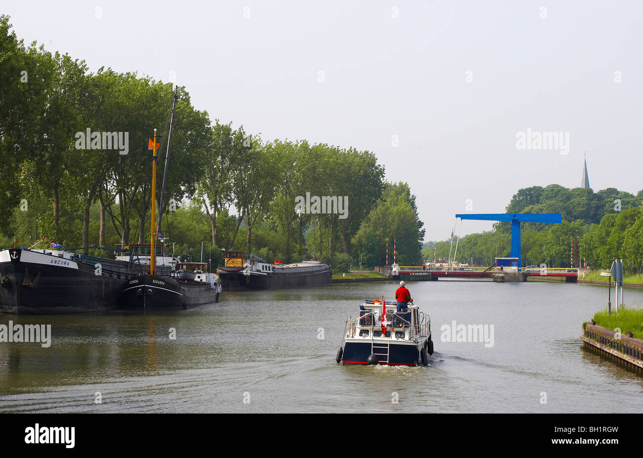 Little boat on the Merwede canal approaching a bascule bridge ...