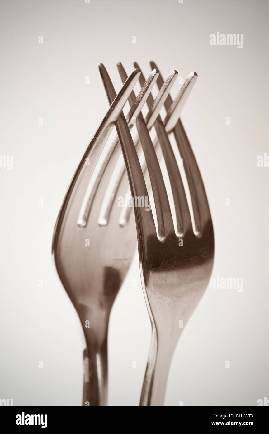Two Entwined Forks on white background Stock Photo - Alamy