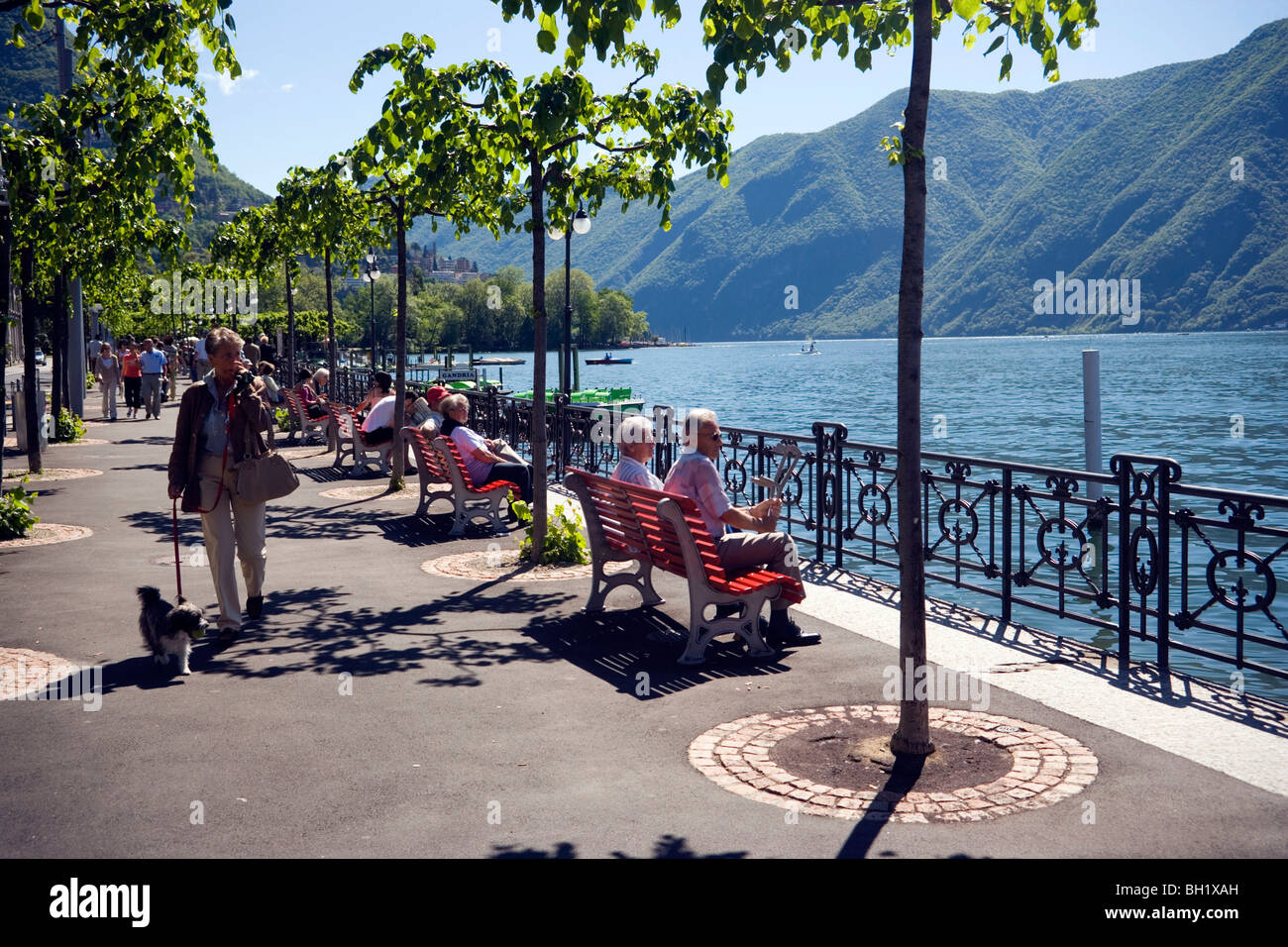 Two women sitting on bench at promenade, Lugano, Lake Lugano, Ticino ...