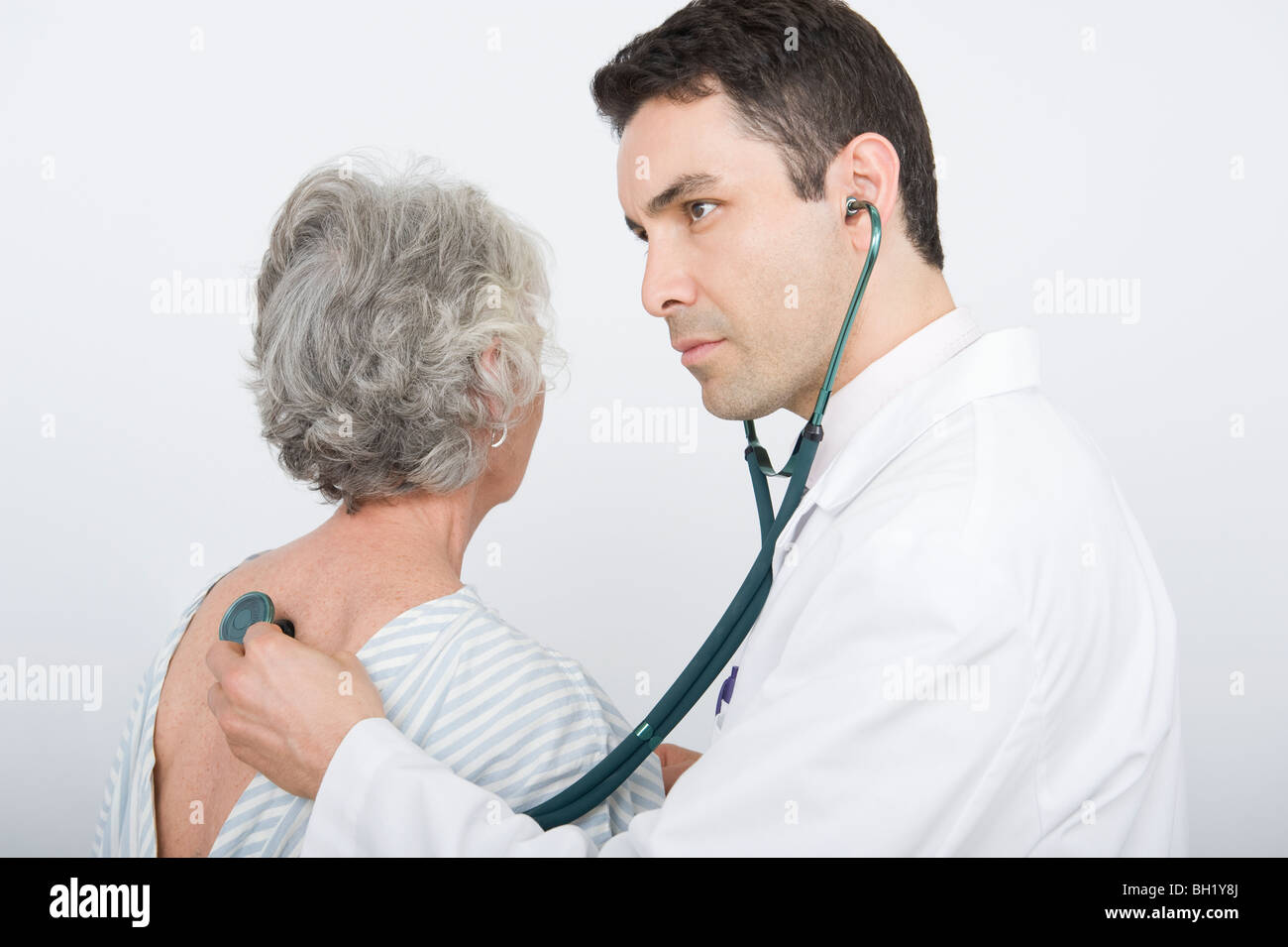 Mid adult doctor checks breathing of senior patient Stock Photo - Alamy