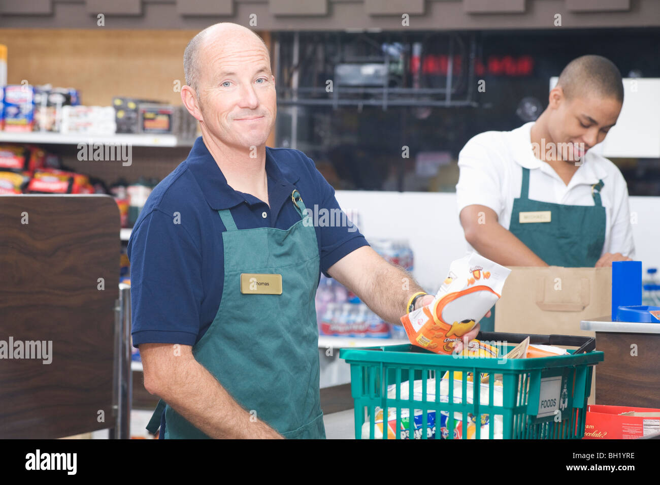 Supermarket employee and check out assistant Stock Photo - Alamy