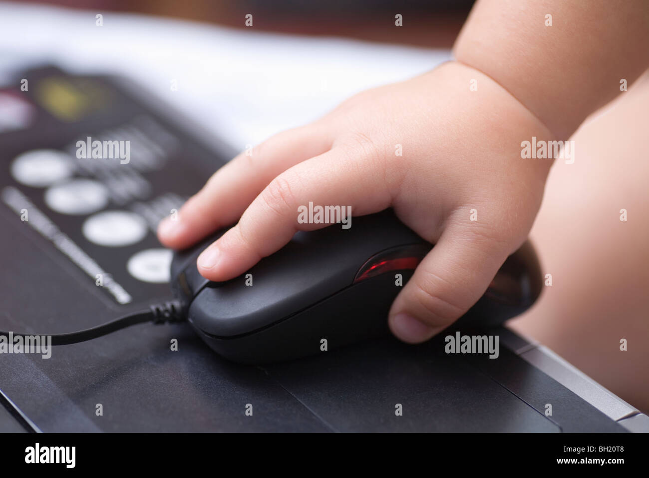Baby's hand holds computer mouse Stock Photo - Alamy