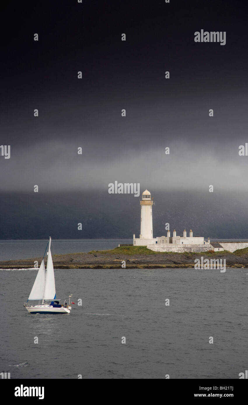 Sailboat near a shore with a lighthouse Stock Photo - Alamy