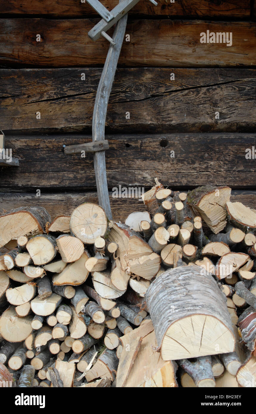 A pile of logs set against a rustic wooden background with an old ...