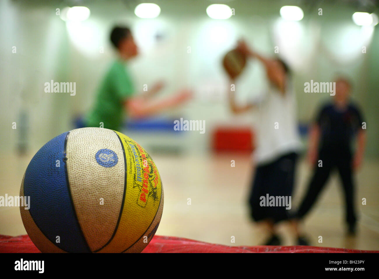 Basketball game (out of focus) with basketball in foreground Stock ...