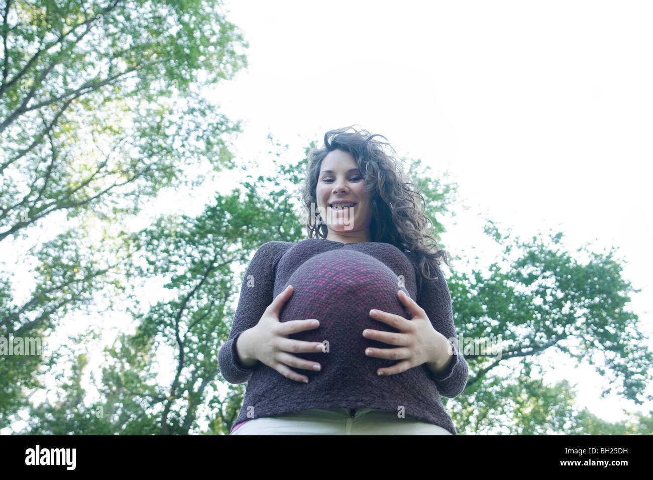 Low Angle Of Very Pregnant Woman With Hands On Abdomen, Manitoba ...
