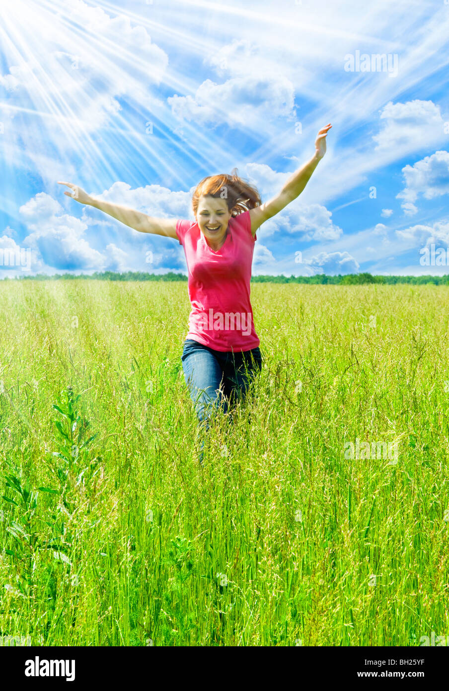 beautiful spreading her arms in the middle of a field Stock Photo - Alamy