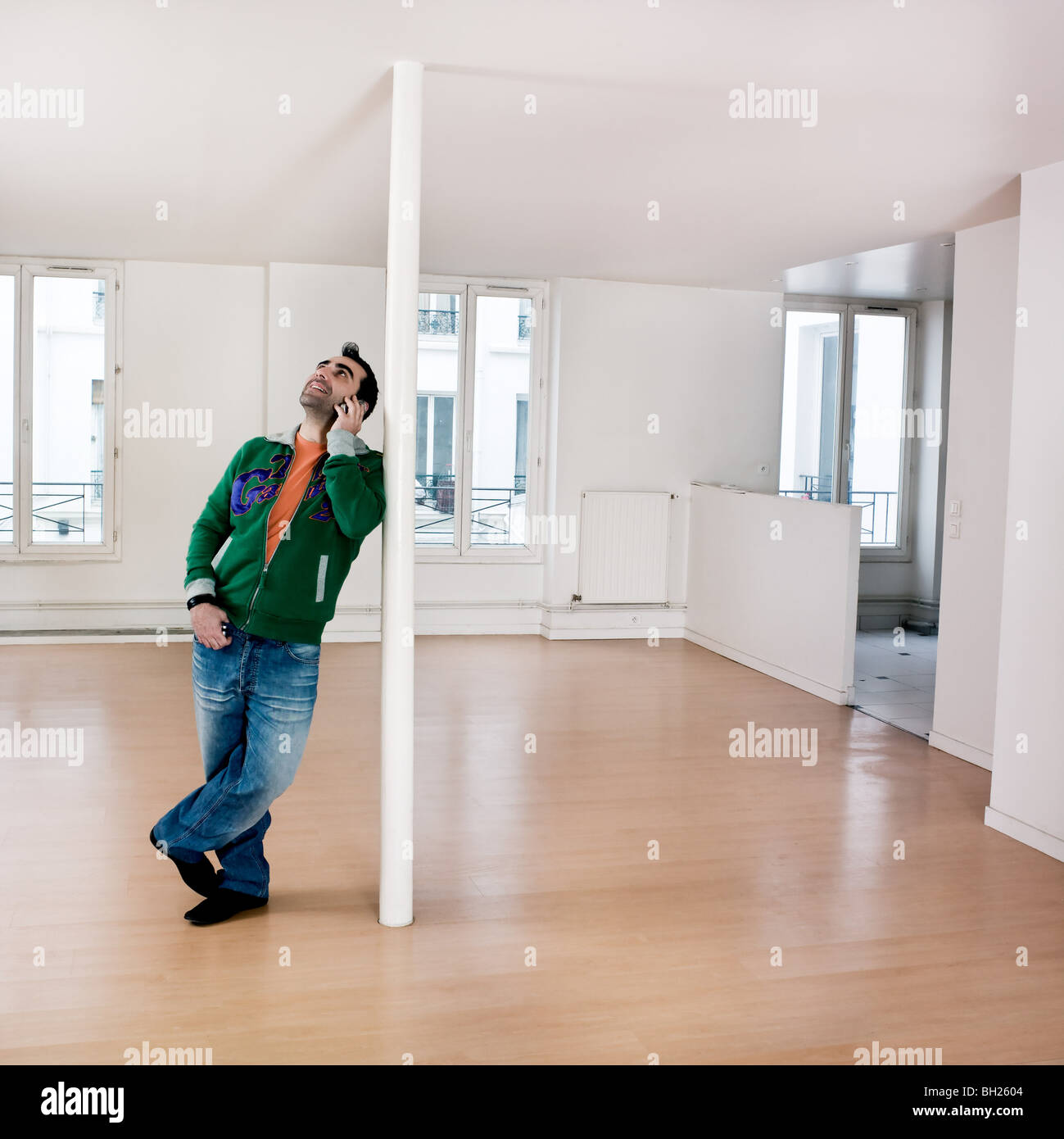 man alone inside an empty loft appartement calling by phone Stock Photo ...