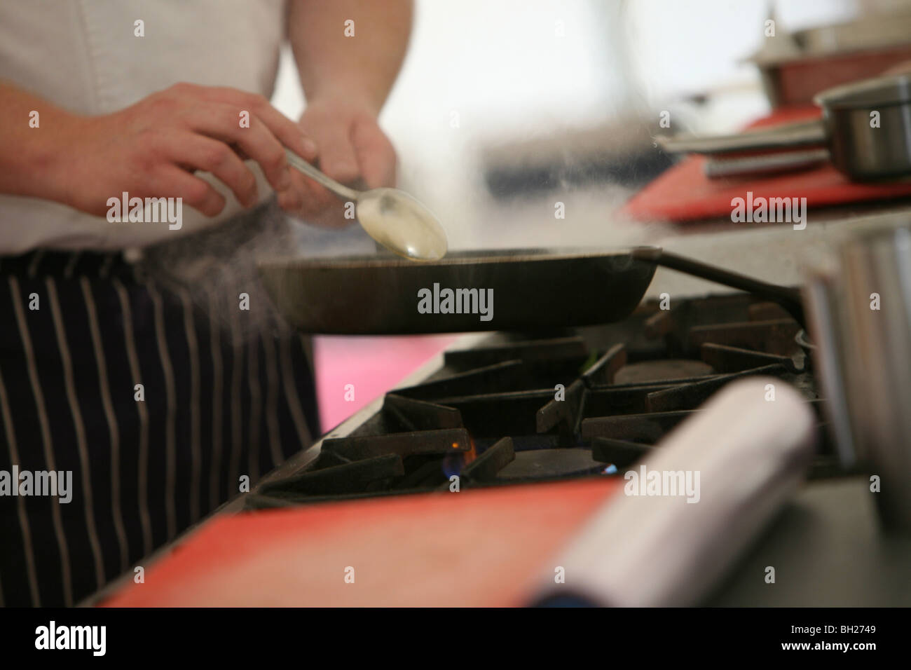 Chef frying food on a gas hob Stock Photo - Alamy