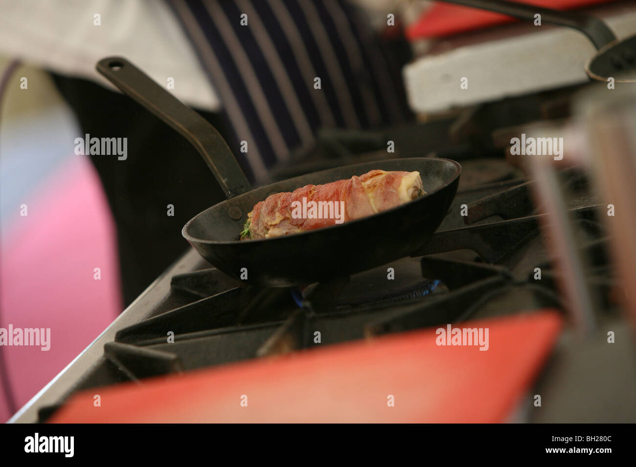 Chef frying food on a gas hob Stock Photo - Alamy