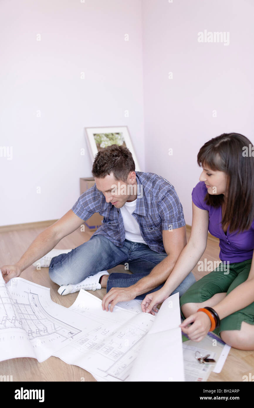 man and woman standing in an empty room on the floor making plans Stock ...