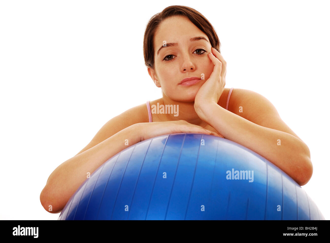 Young woman looking bored resting on gym ball Stock Photo - Alamy
